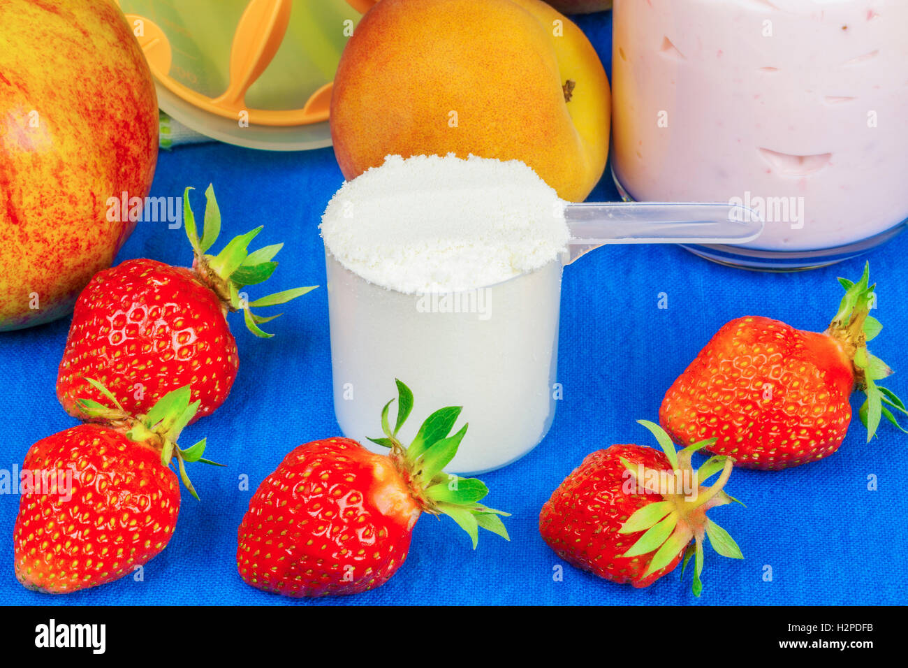 Plastic cup of protein powder with fruits around Stock Photo - Alamy