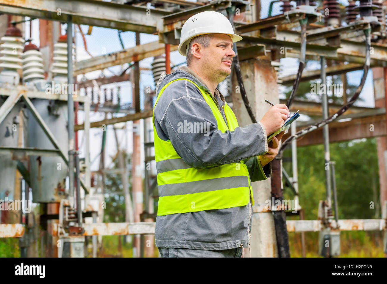 Electrician writing in electrical substation Stock Photo - Alamy