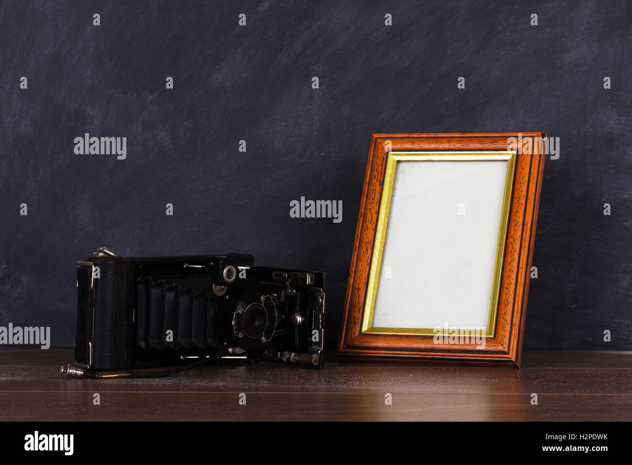 Old vintage camera and frame against blackboard background Stock Photo ...