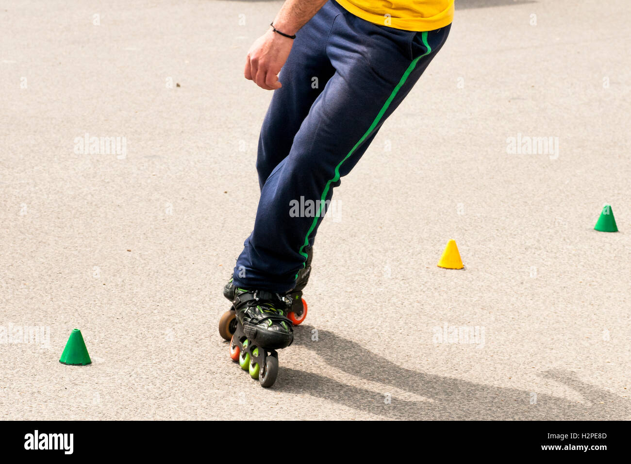 Roller skater practicing slalom along a line of cones on asphalt Stock ...