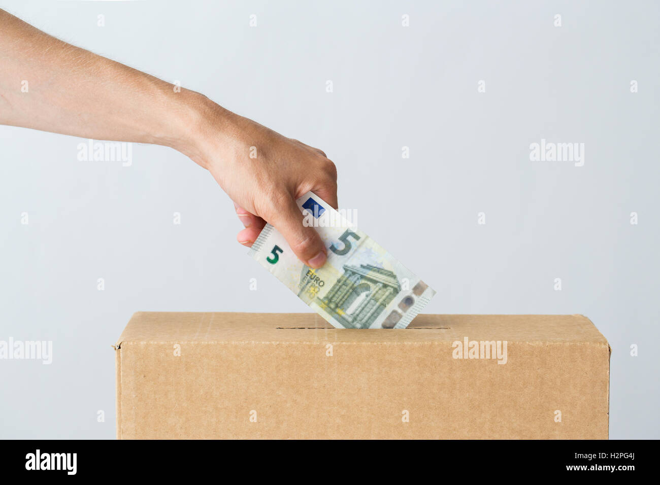 man putting euro money into donation box Stock Photo - Alamy