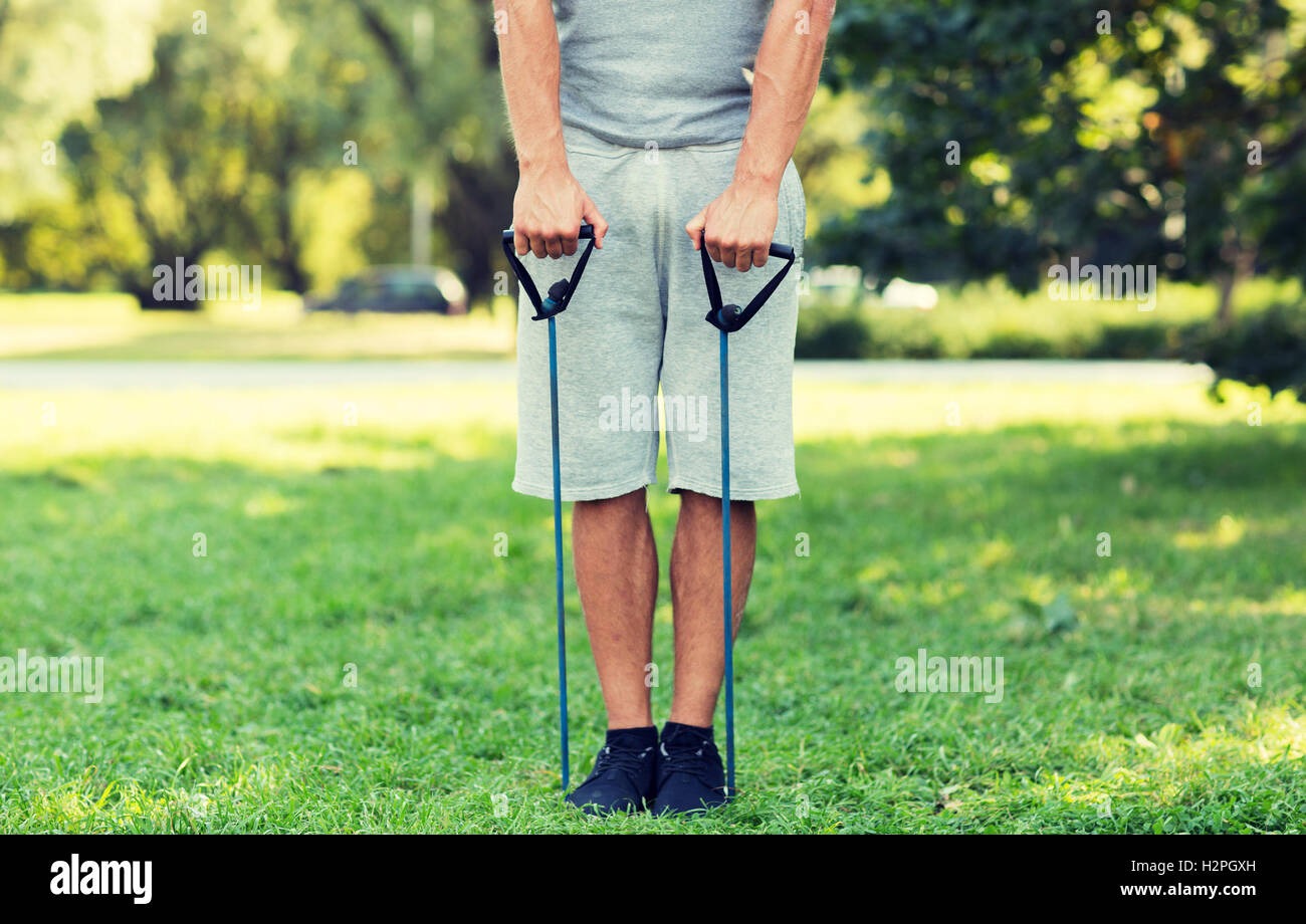 young man exercising with expander in summer park Stock Photo - Alamy
