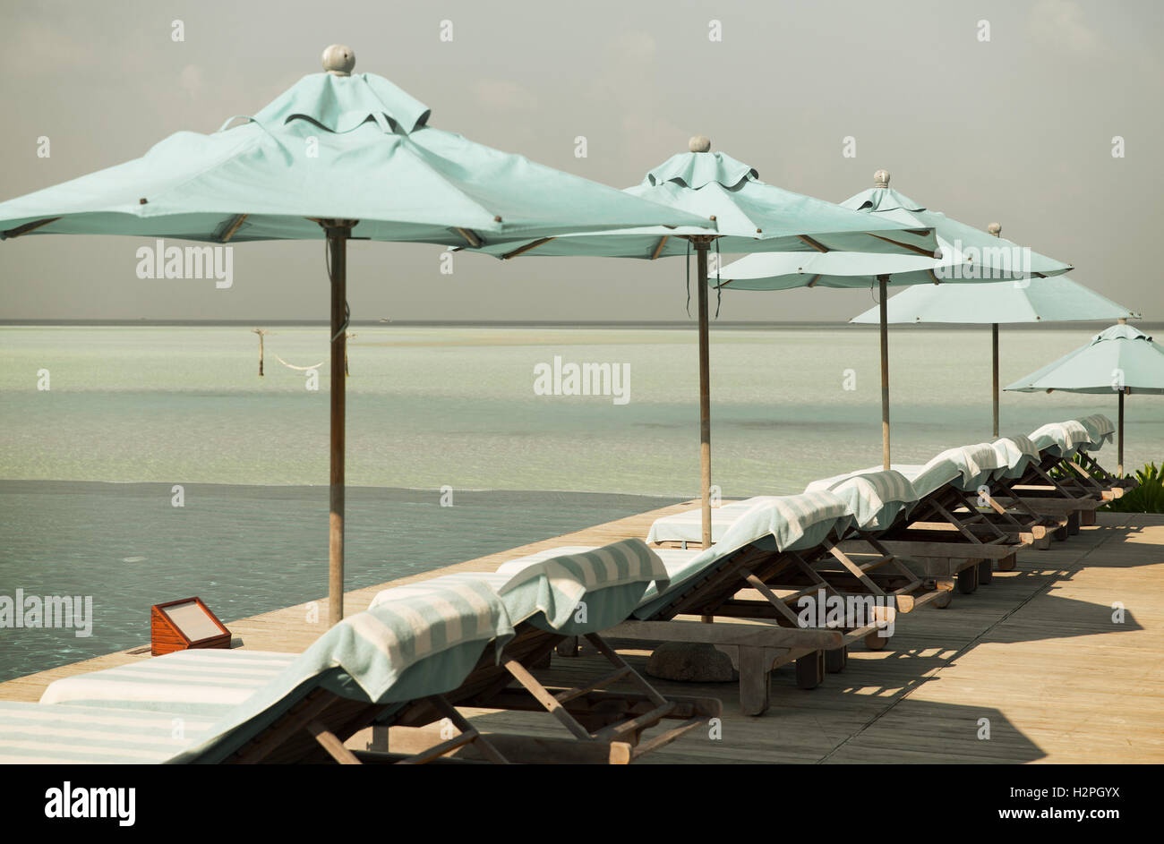 parasol and sunbeds by sea on maldives beach Stock Photo - Alamy