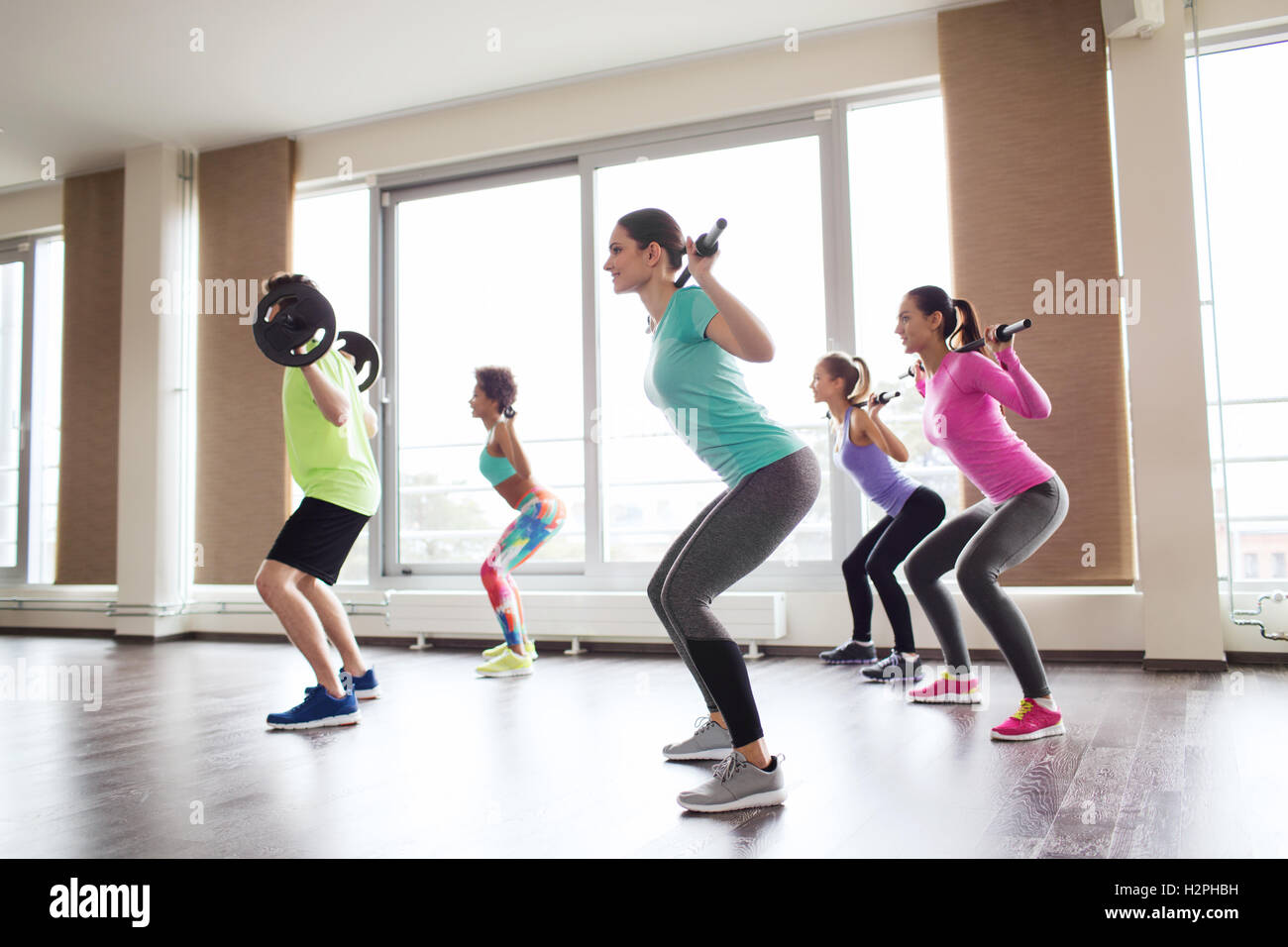 group of people exercising with barbell in gym Stock Photo - Alamy