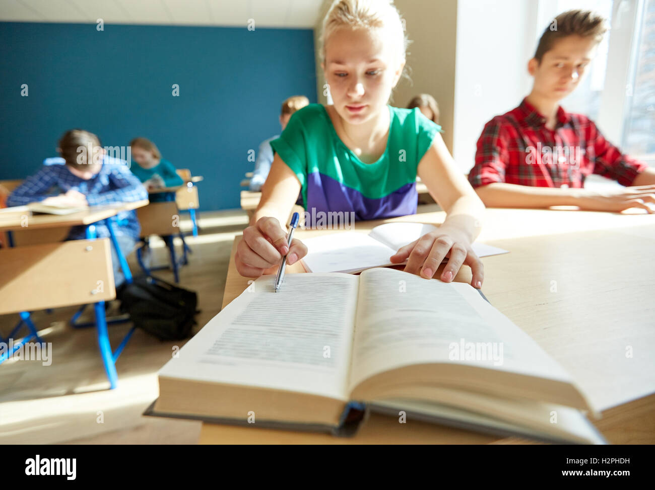 group of students with books writing school test Stock Photo - Alamy