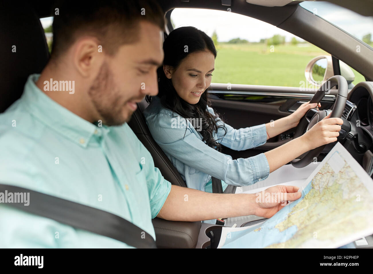 happy man and woman with road map driving in car Stock Photo - Alamy