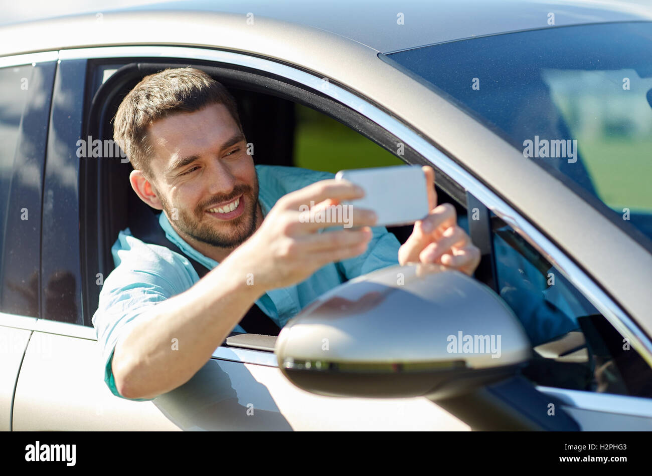 happy smiling man with smartphone driving in car Stock Photo - Alamy