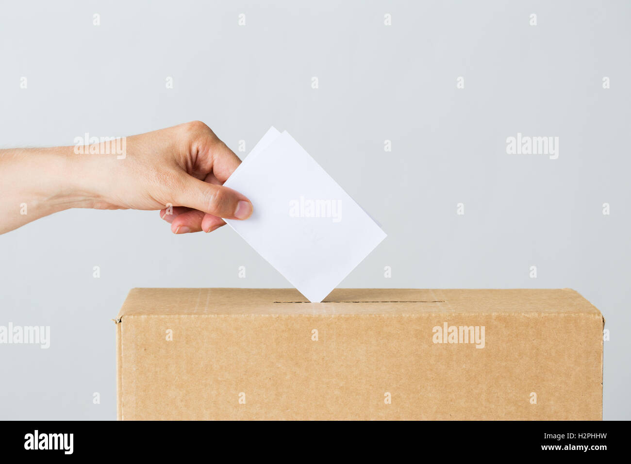 man putting his vote into ballot box on election Stock Photo - Alamy
