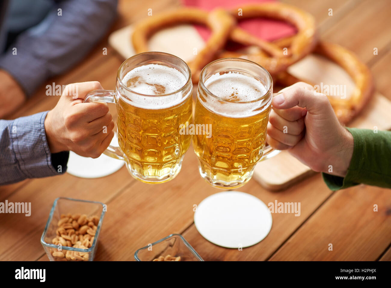 close up of hands clinking beer mugs at bar or pub Stock Photo - Alamy