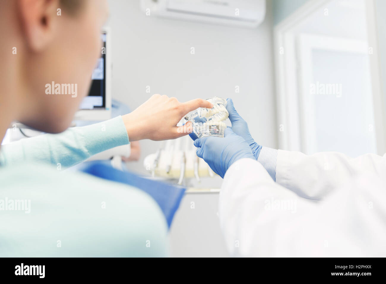 close up of dentist with teeth model and patient Stock Photo - Alamy