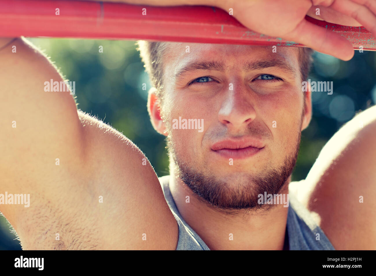 young man exercising on horizontal bar outdoors Stock Photo - Alamy