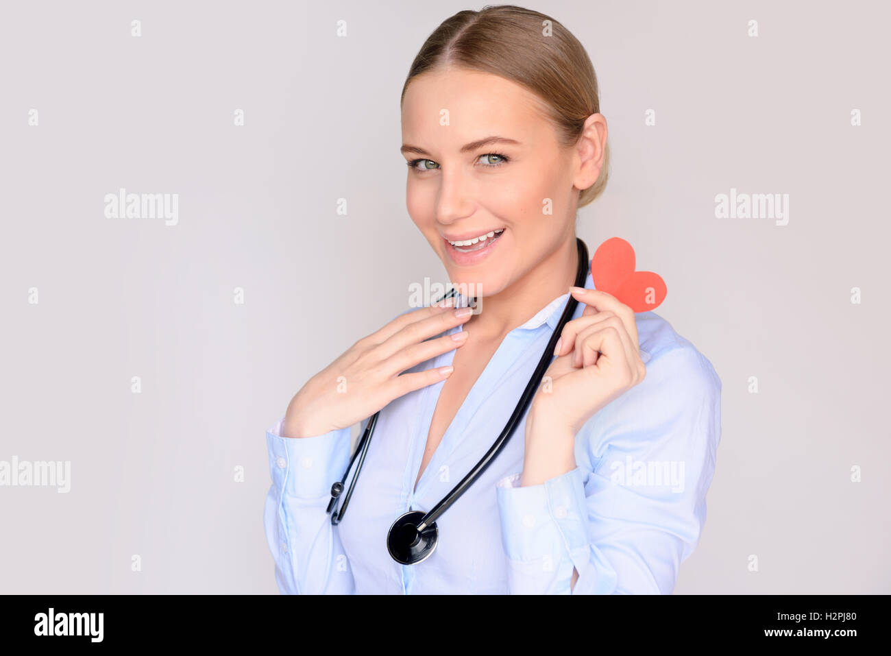 Portrait of a happy cardiologist doctor with conceptual paper heart in ...