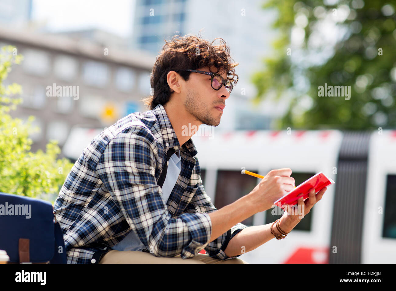 man with notebook or diary writing on city street Stock Photo - Alamy