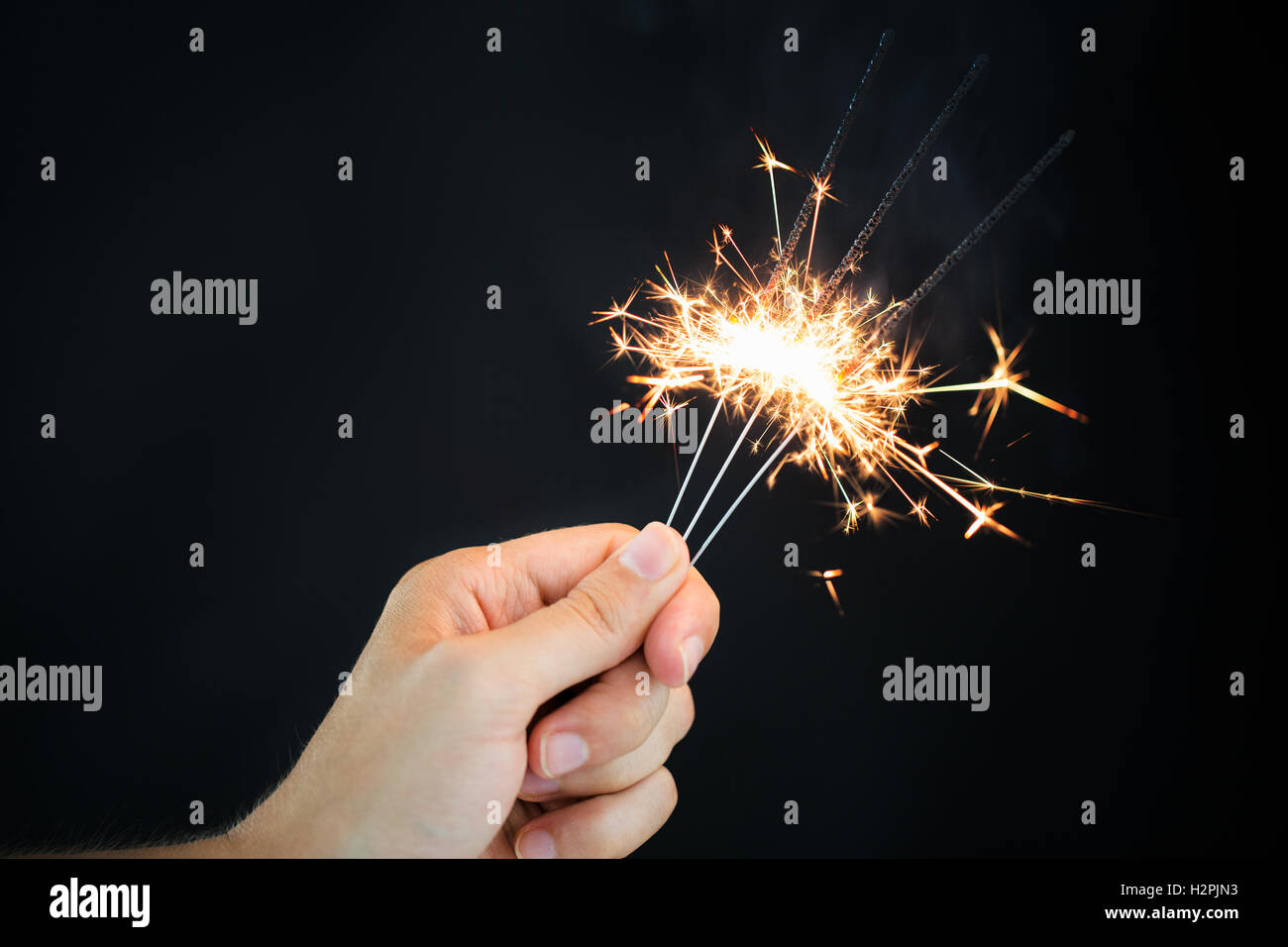 hand holding sparklers over black background Stock Photo - Alamy