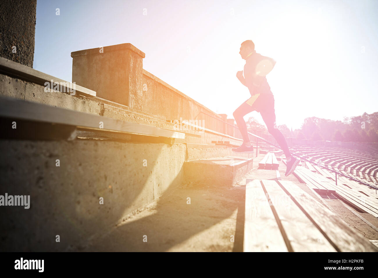 happy young man running upstairs on stadium Stock Photo - Alamy
