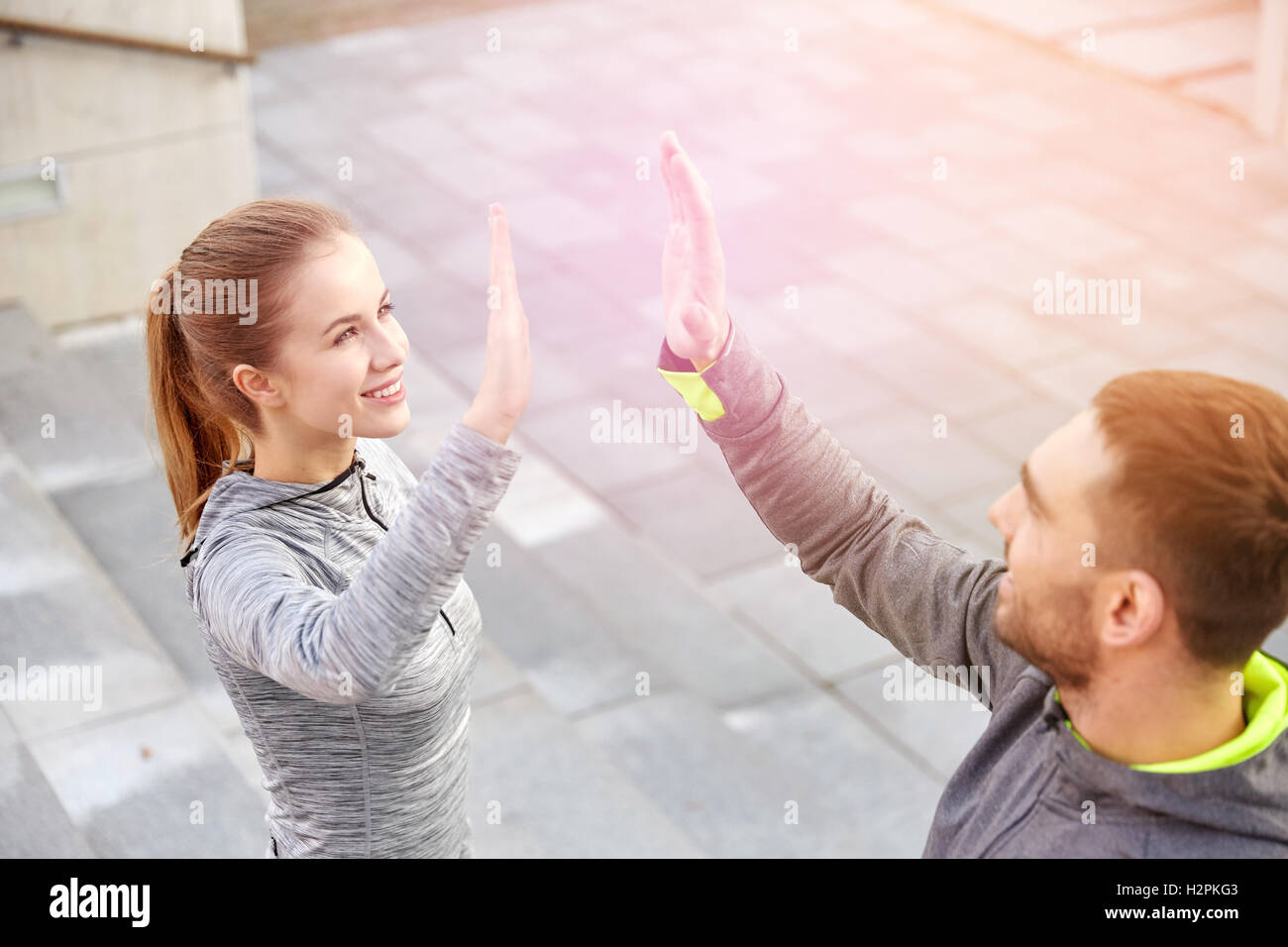smiling couple making high five on city street Stock Photo - Alamy