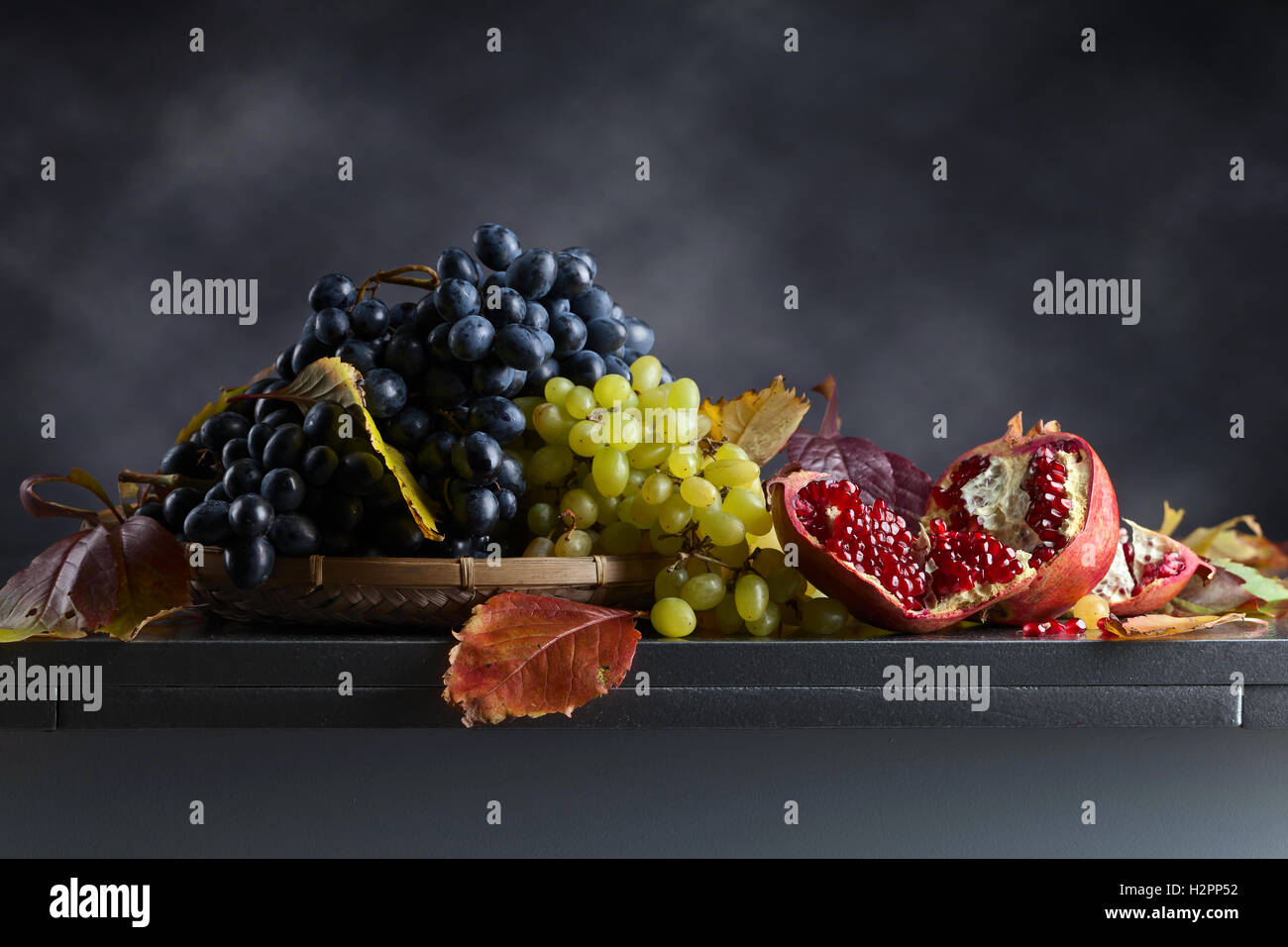 blue and green grapes with pomegranate on a kitchen table Stock Photo ...
