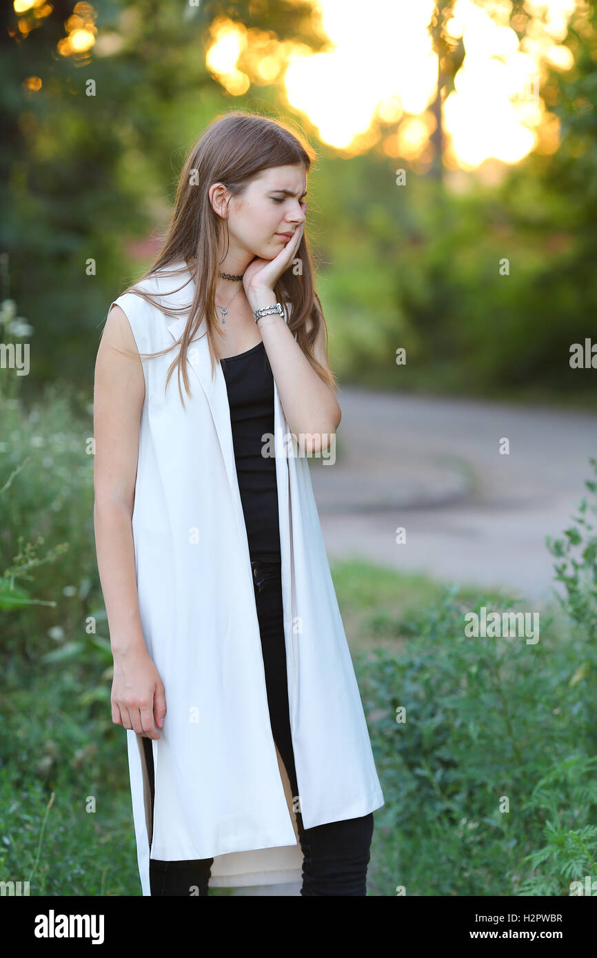Woman with long hair and beautiful eyes on a green background shows the ...