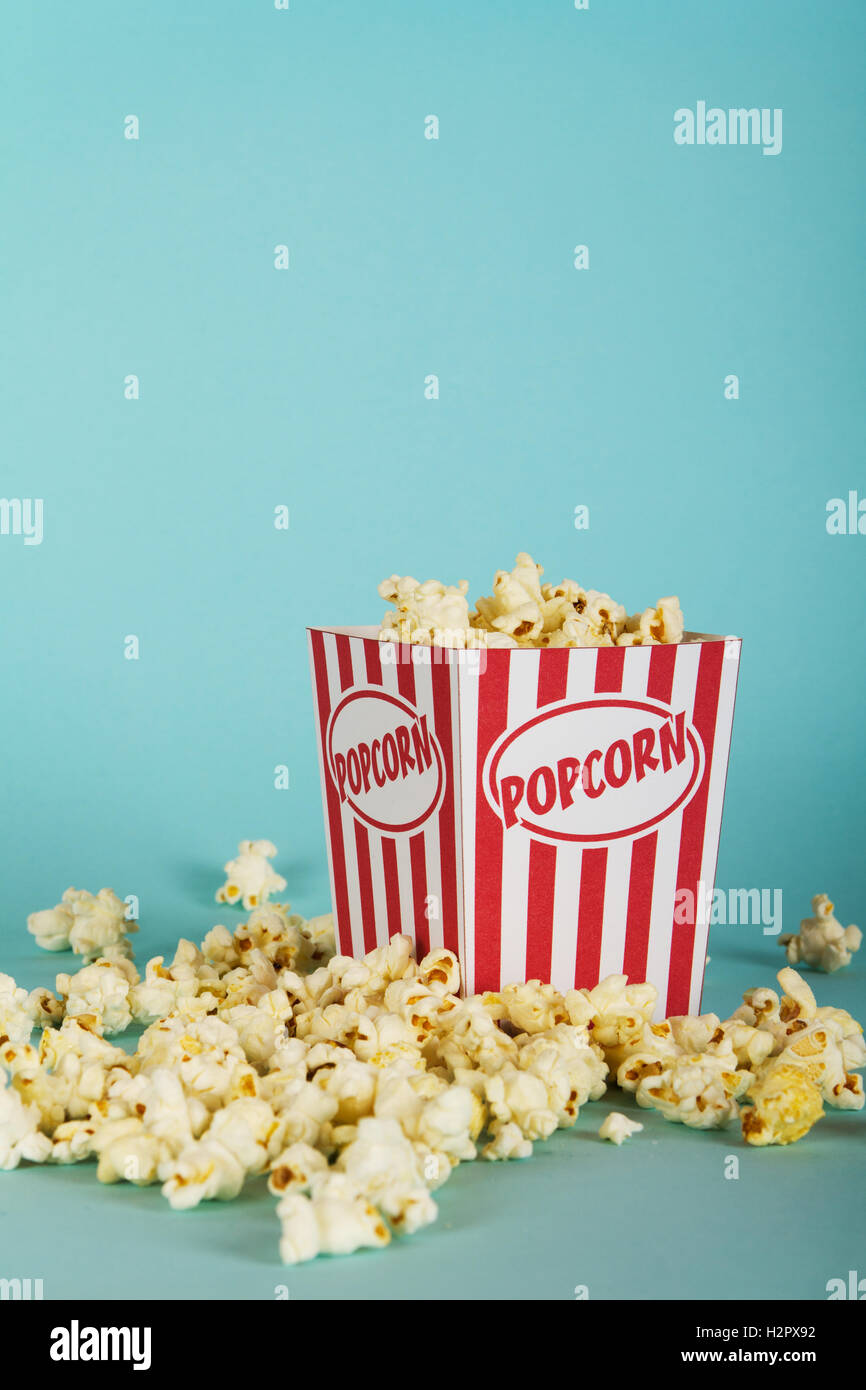 Bucket of popcorn against a blue background Stock Photo - Alamy