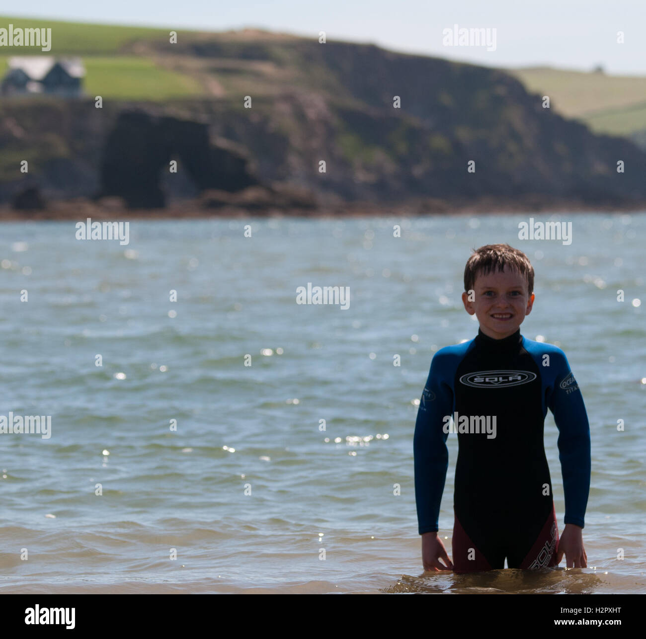 Boy standing in the sea with Thurlestone Rock in the background Stock ...