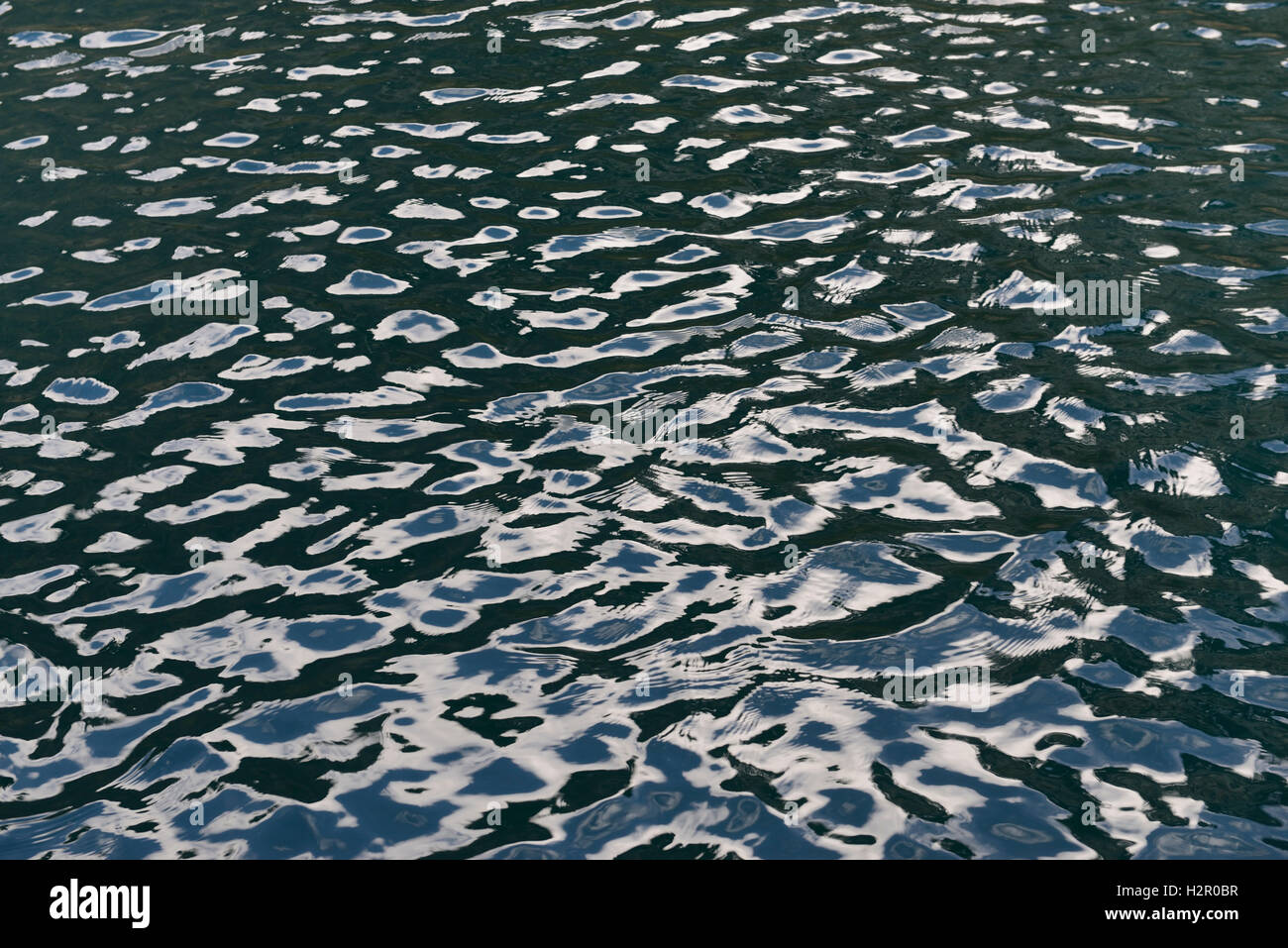 Water ripples on a lake reflecting light Stock Photo - Alamy