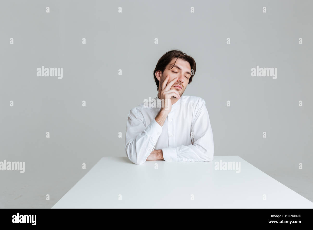 Thoughtful man with eyes closed thinking about something while sitting ...