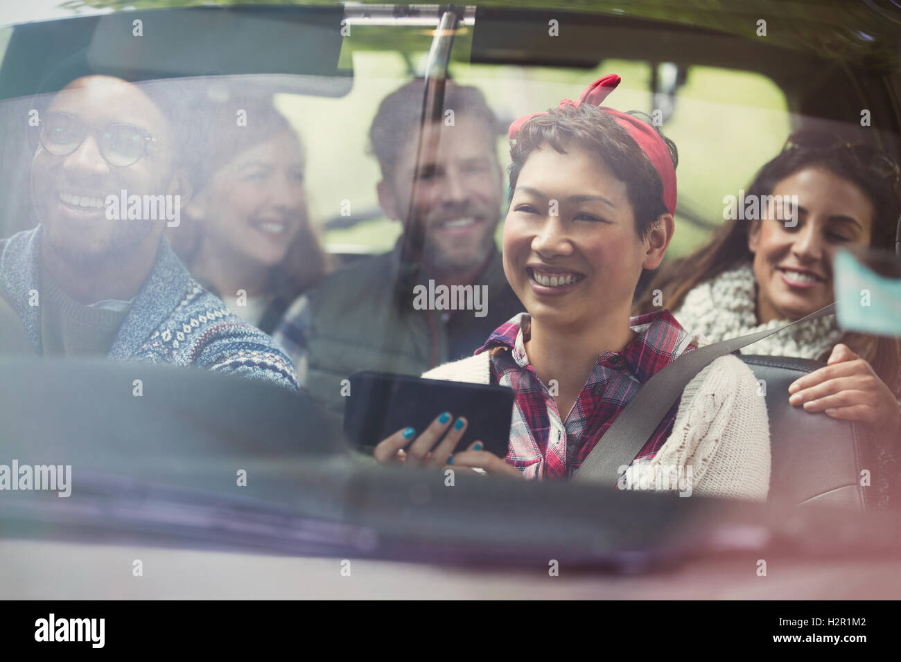 Smiling friends using GPS on smart phone riding in car Stock Photo - Alamy