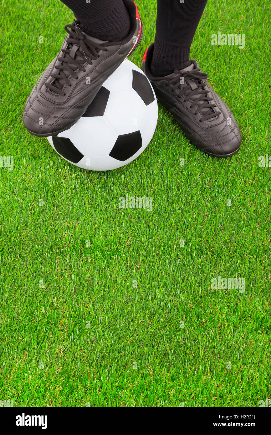 Soccer player's feet and football on field Stock Photo - Alamy