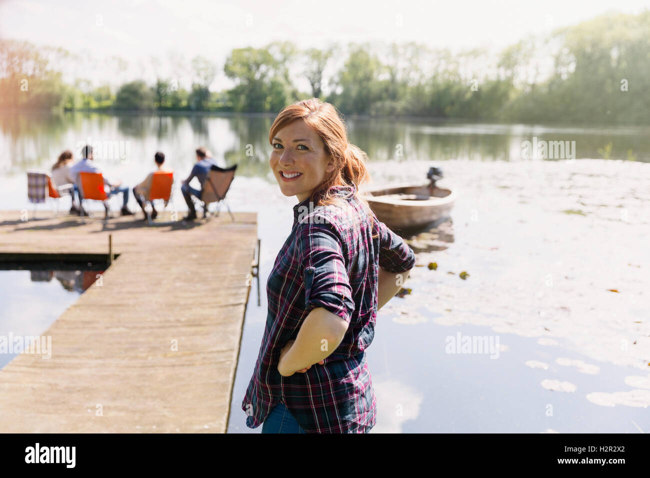 Portrait smiling woman at sunny lakeside dock Stock Photo - Alamy