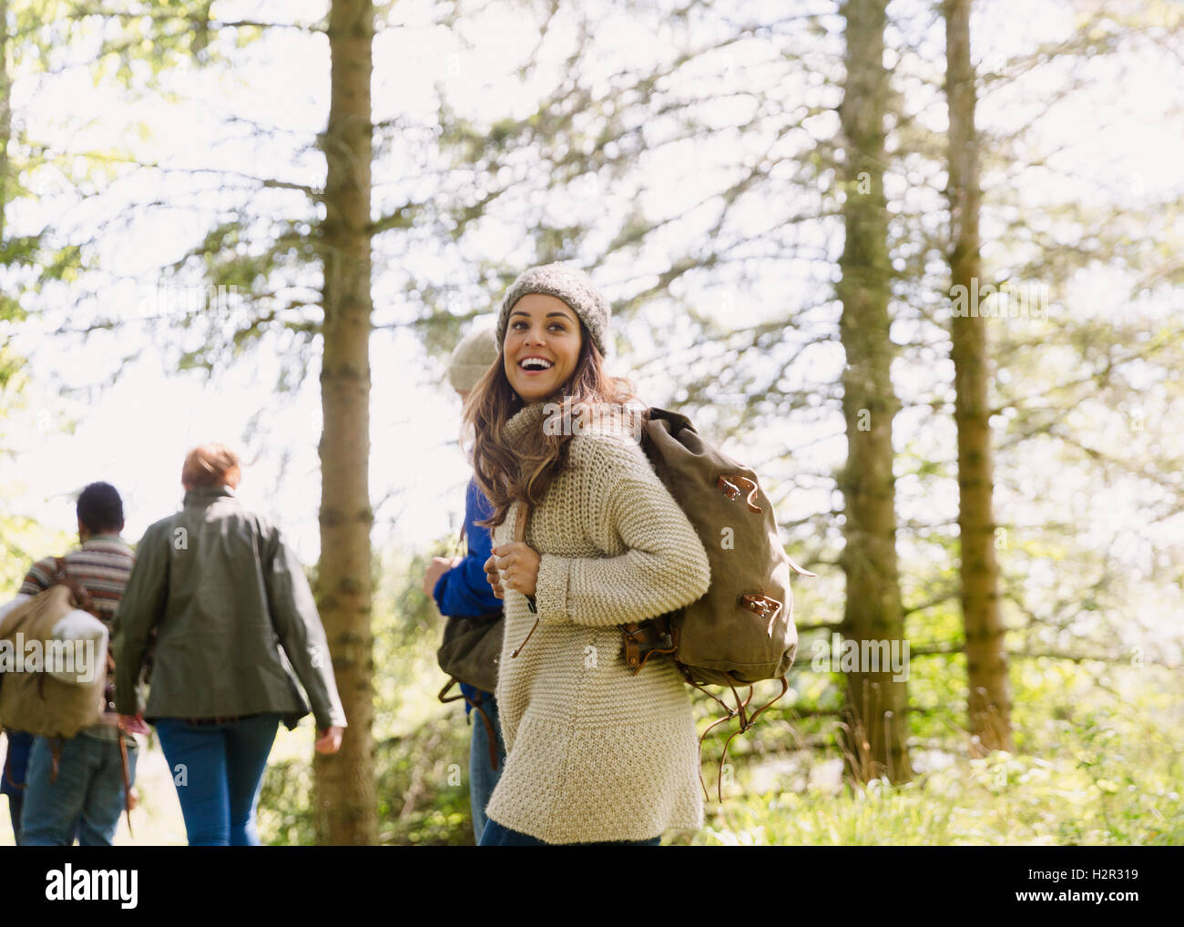 Enthusiastic woman with backpack hiking in sunny woods Stock Photo - Alamy