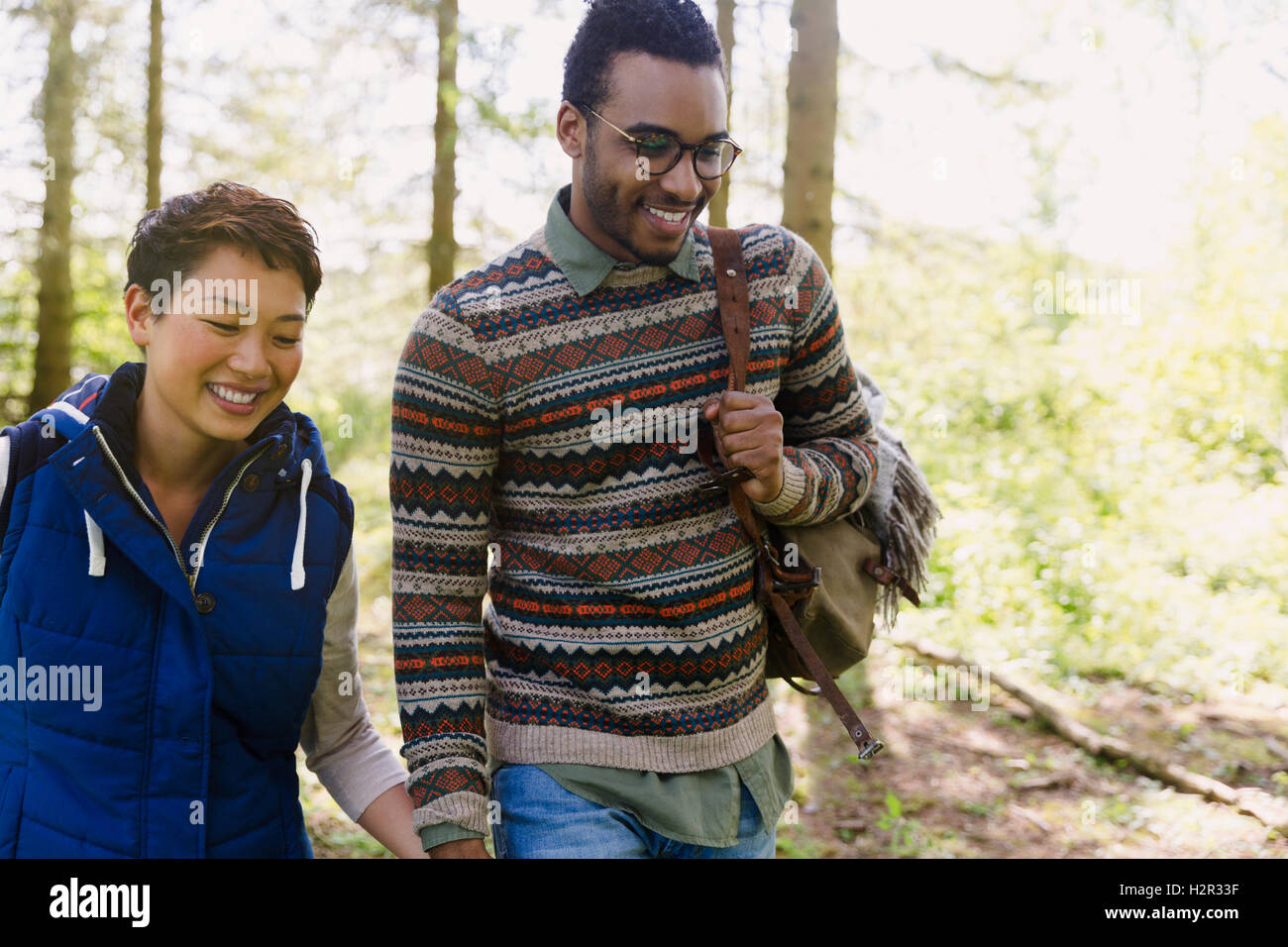 Couple holding hands hiking in woods Stock Photo - Alamy
