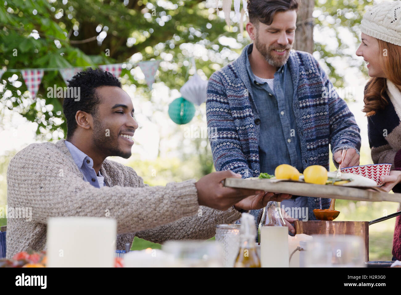 Friends passing food at patio lunch Stock Photo - Alamy
