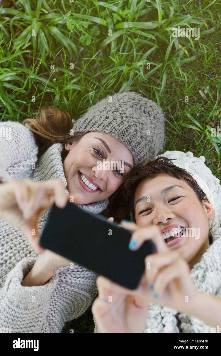 Overhead view smiling women taking selfie with camera phone in grass ...
