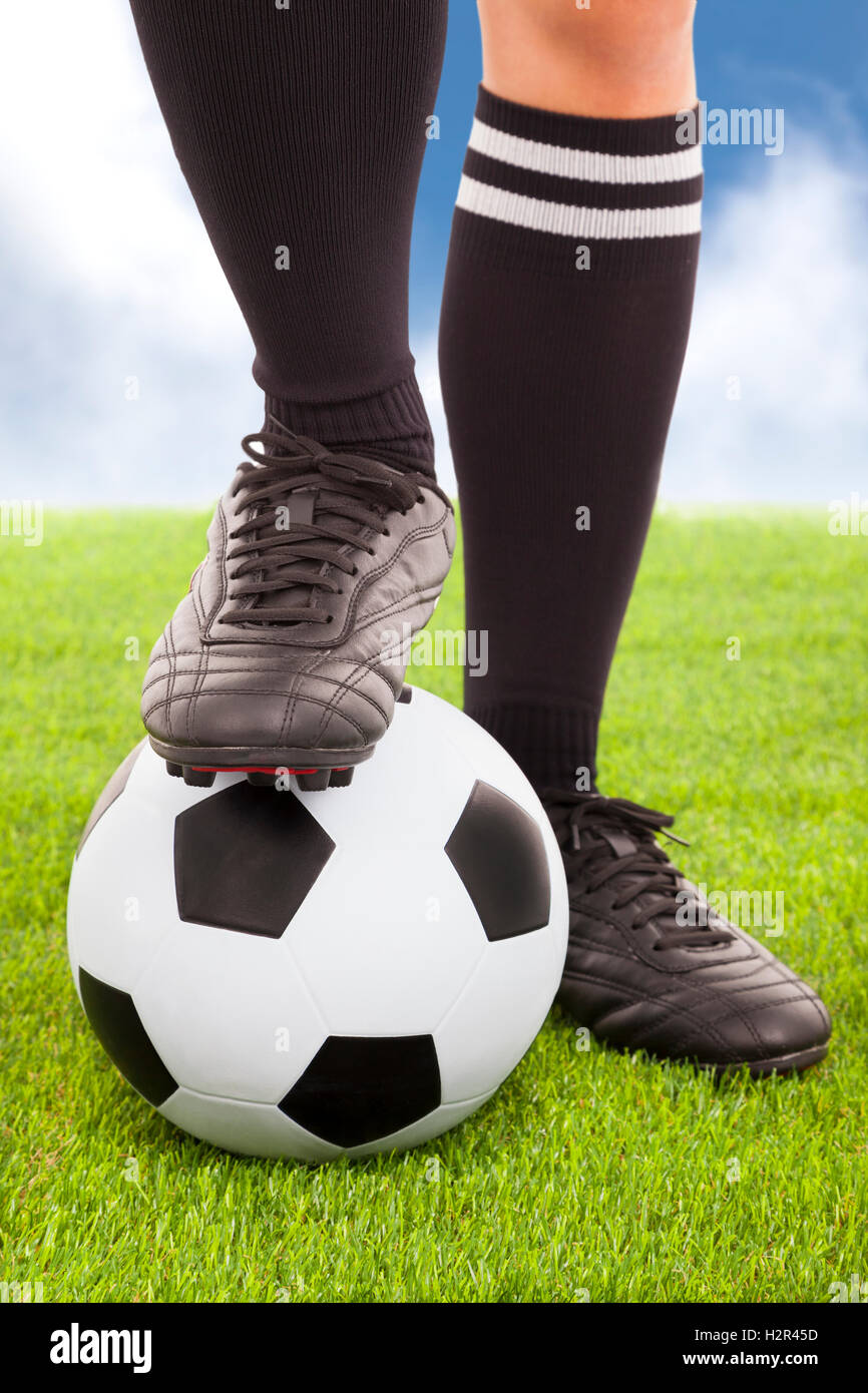 Soccer player's feet and football with sky background Stock Photo - Alamy