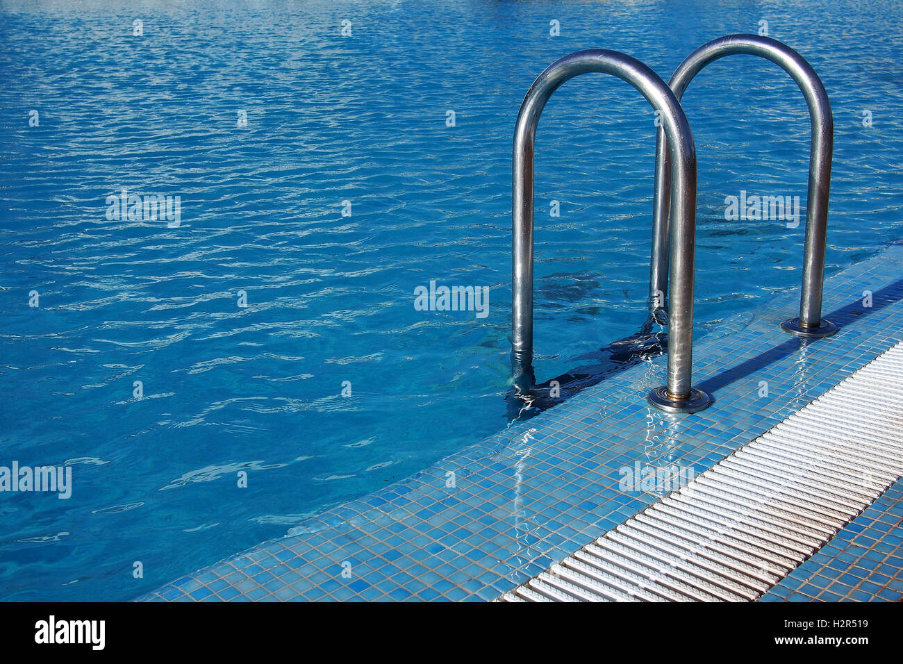 Swimming pool with steel ladder Stock Photo - Alamy