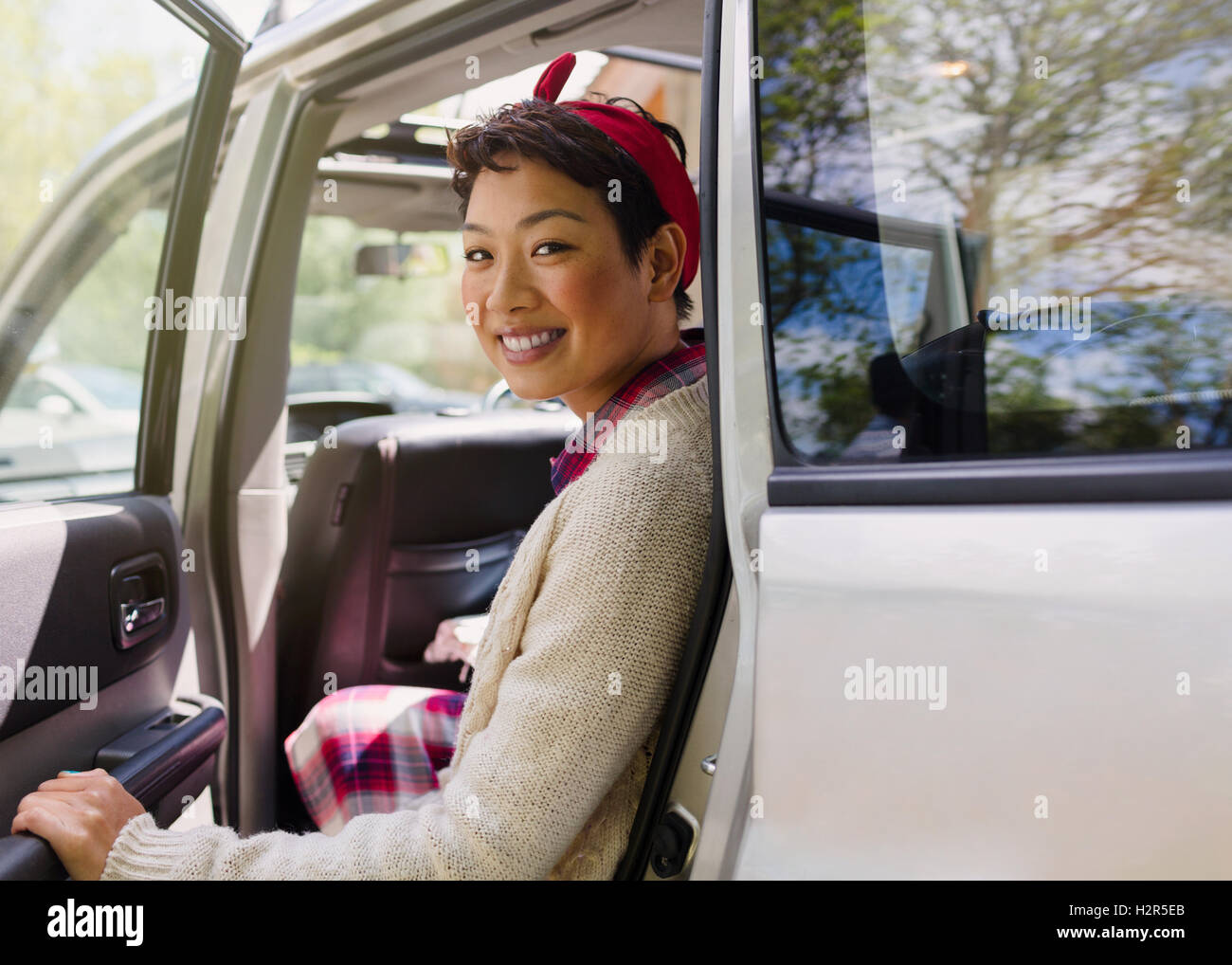 Portrait smiling woman getting out of car Stock Photo - Alamy