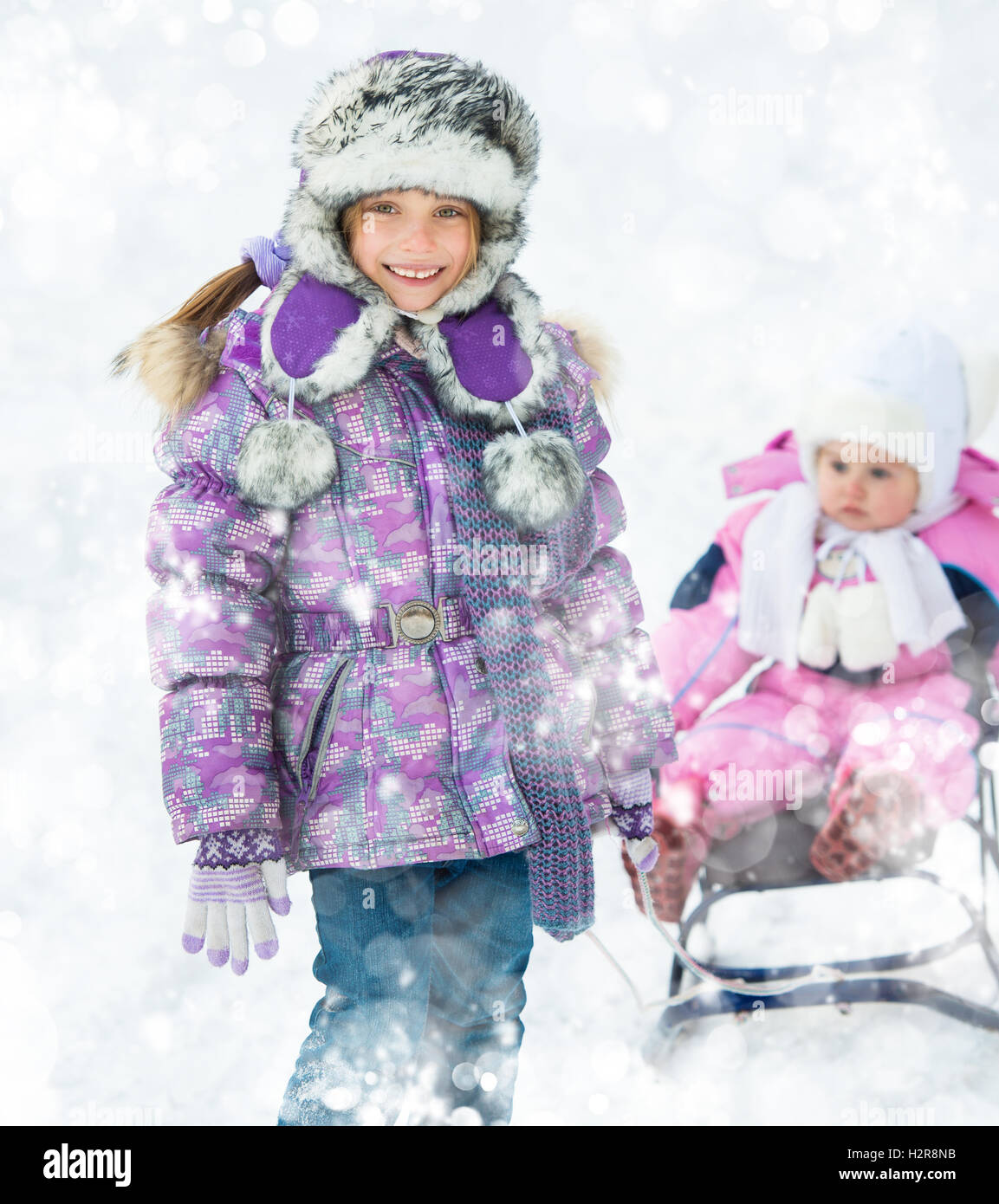 Smiling girl lucky kid sledging Stock Photo - Alamy