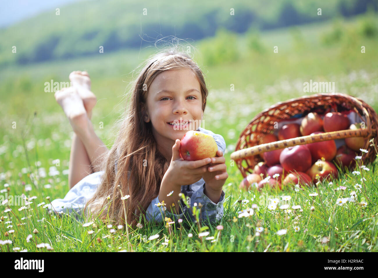 Child eating apple in a field Stock Photo - Alamy