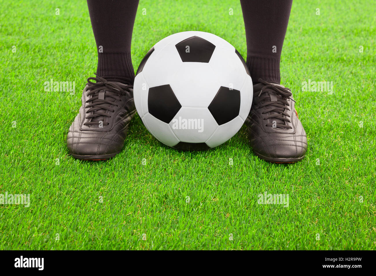 Soccer player's feet with ball on an open playing field Stock Photo - Alamy