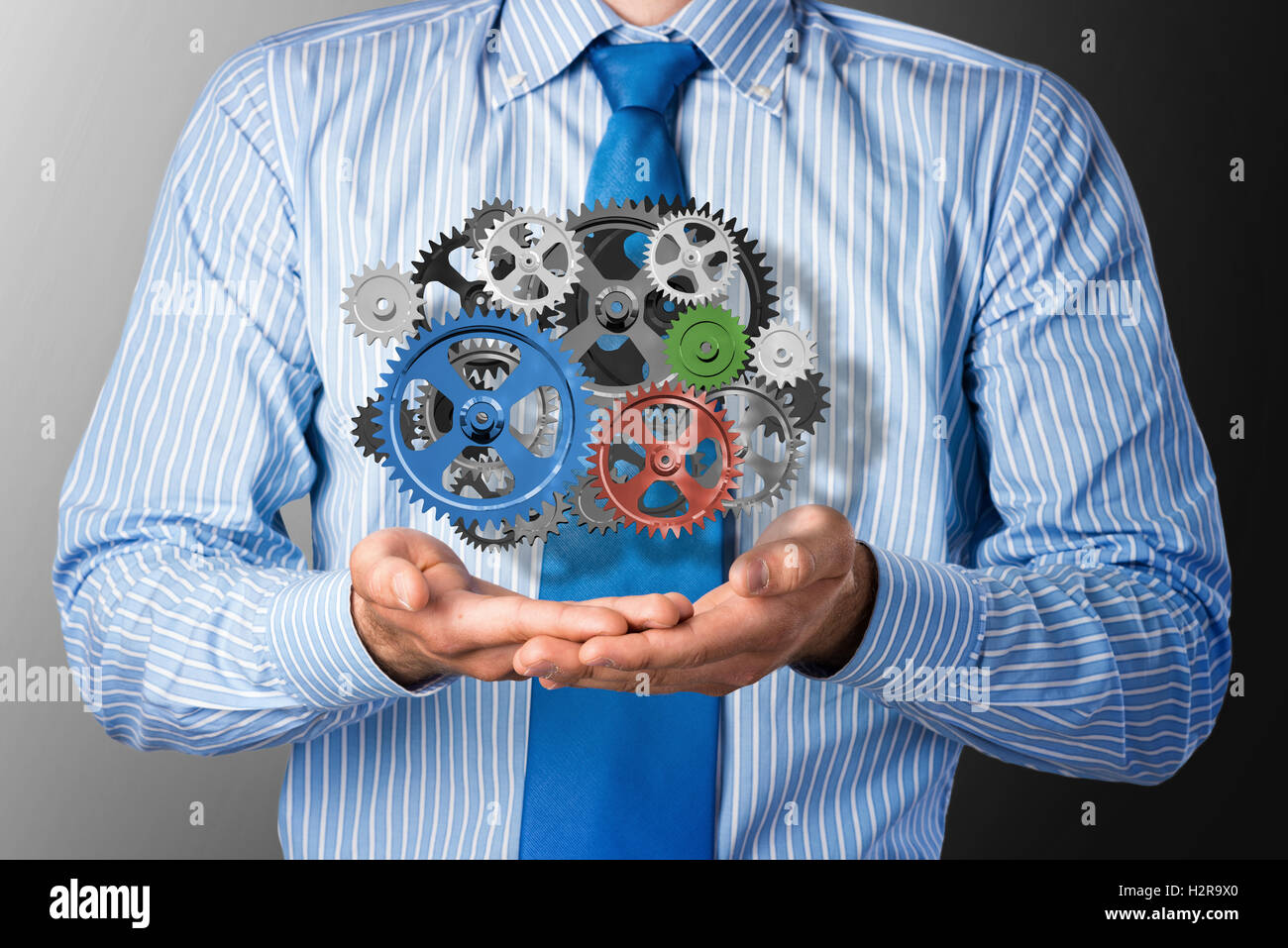 business man holds up a mechanism of gears Stock Photo - Alamy
