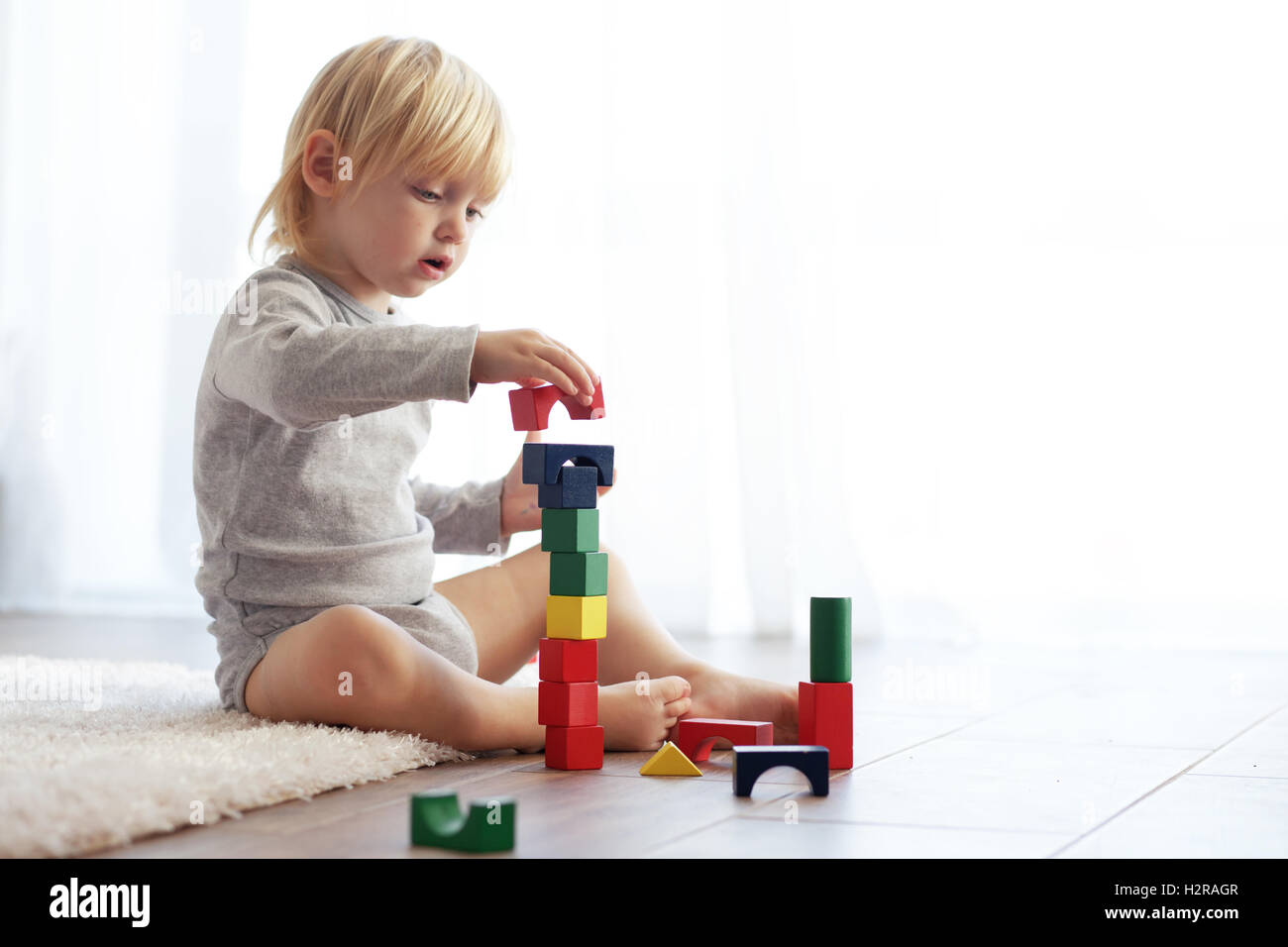 Toddler playing with wooden blocks Stock Photo - Alamy