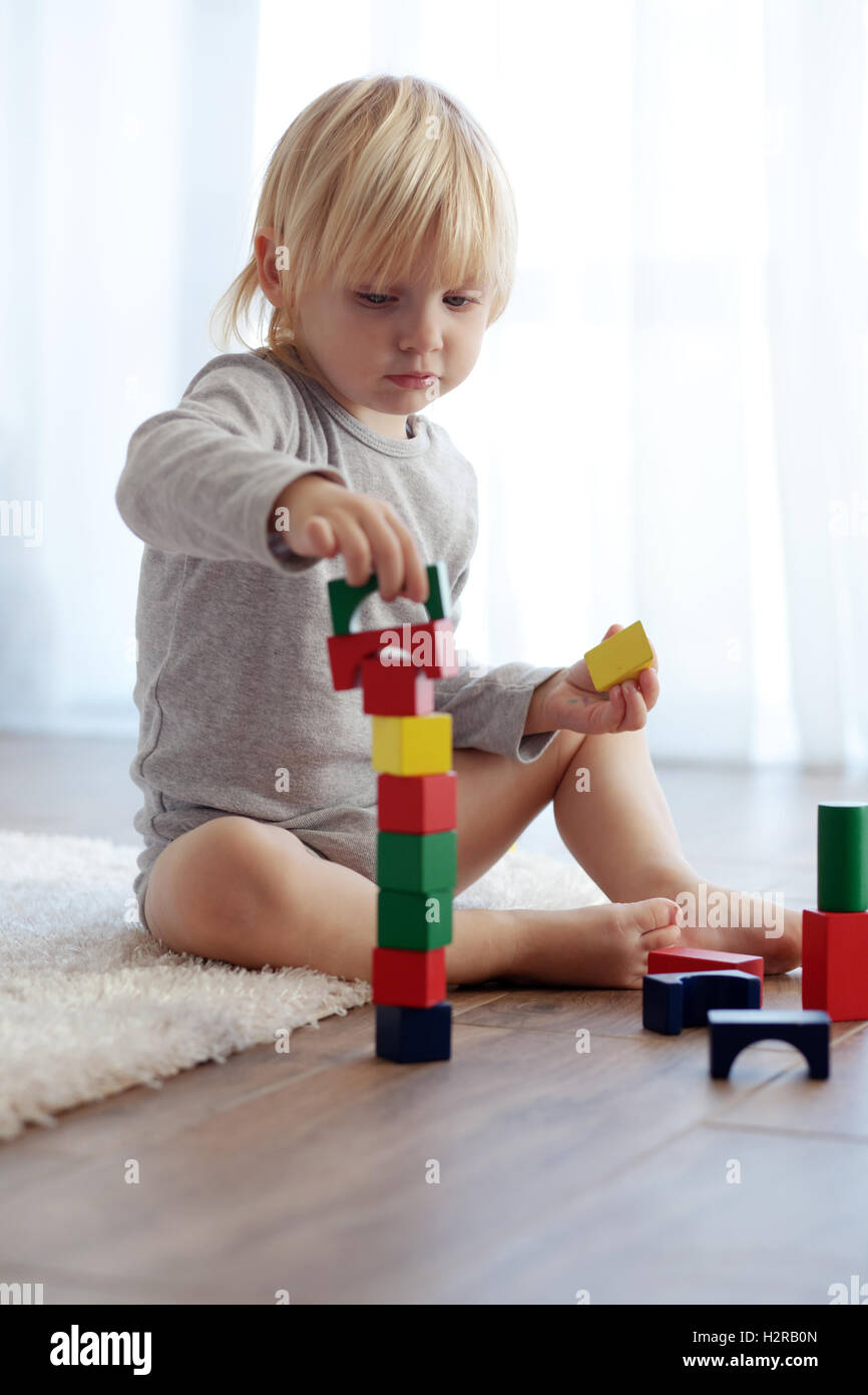 Toddler playing with wooden blocks Stock Photo - Alamy