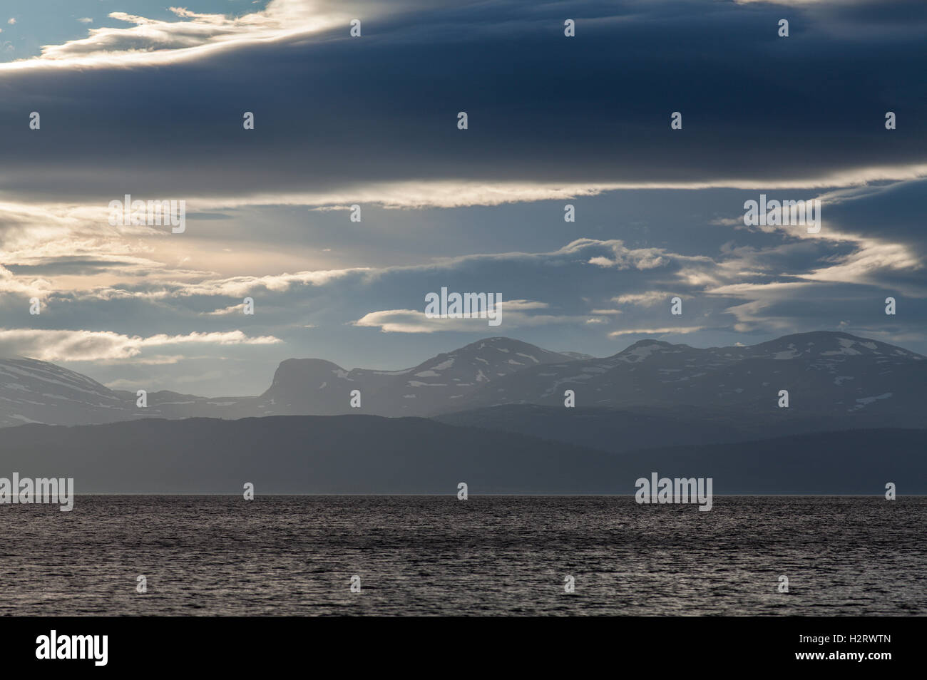 View of a lake and mountains in late evening. Overcast and some wind ...