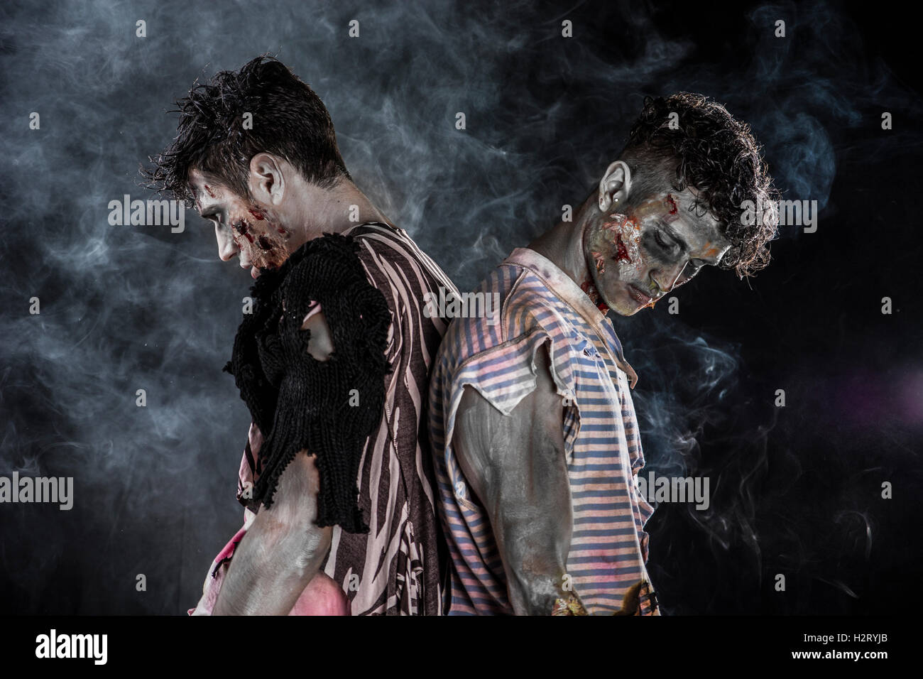 Two male zombies standing on black smoky background, head and shoulder ...