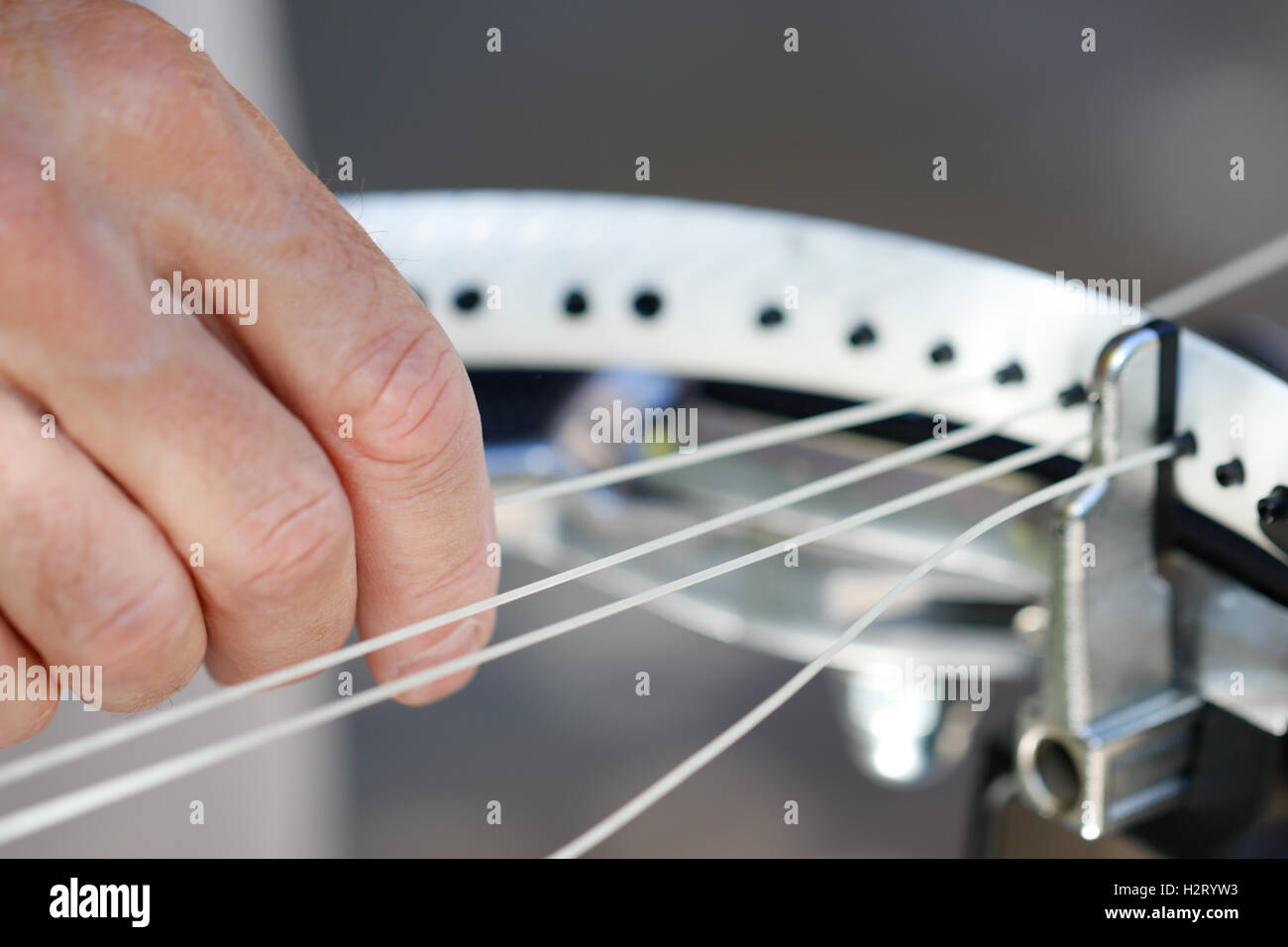 A older white male stringing a tennis racket Stock Photo - Alamy