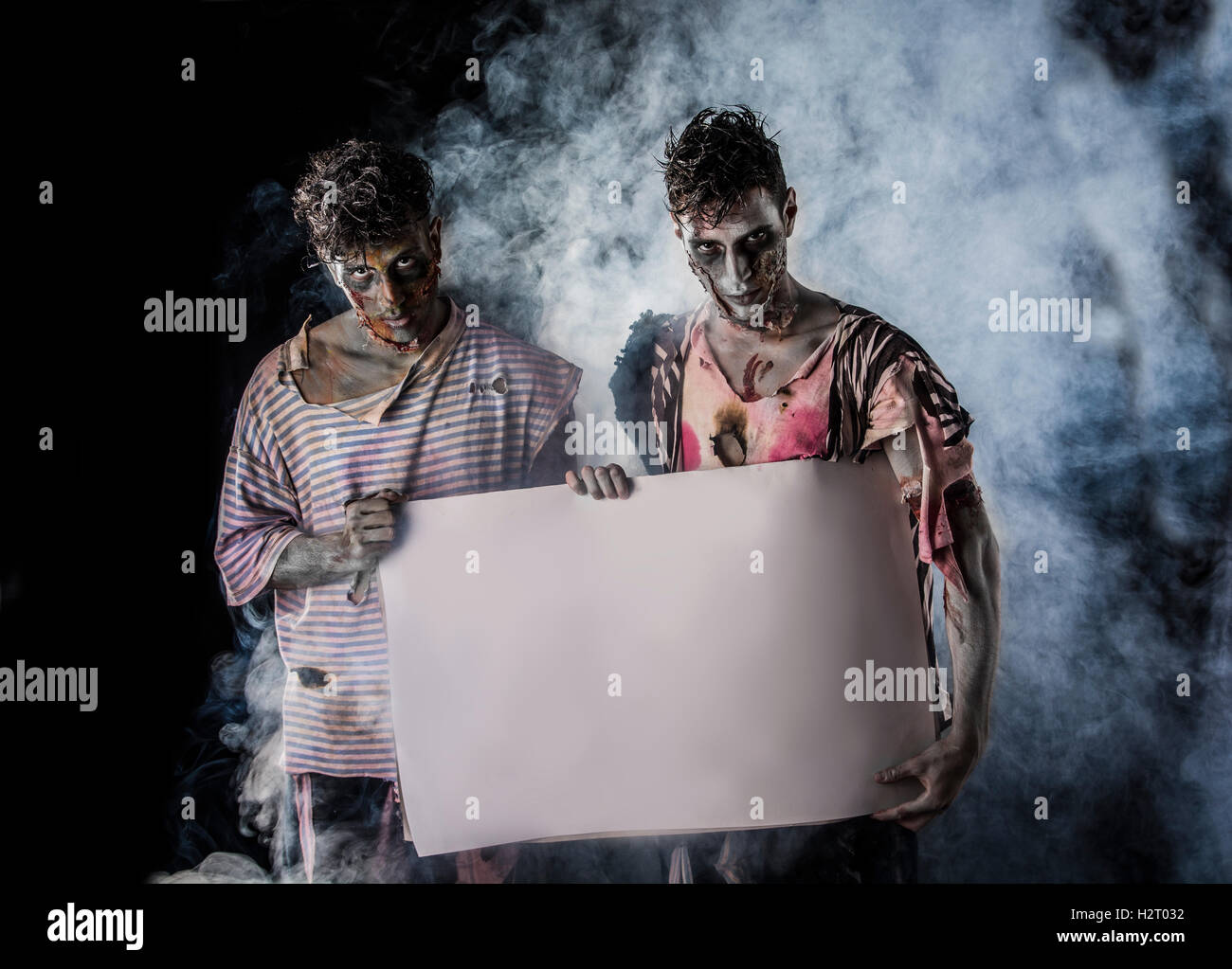 Two Male Zombies Holding Empty White Banner on Dark Background and ...