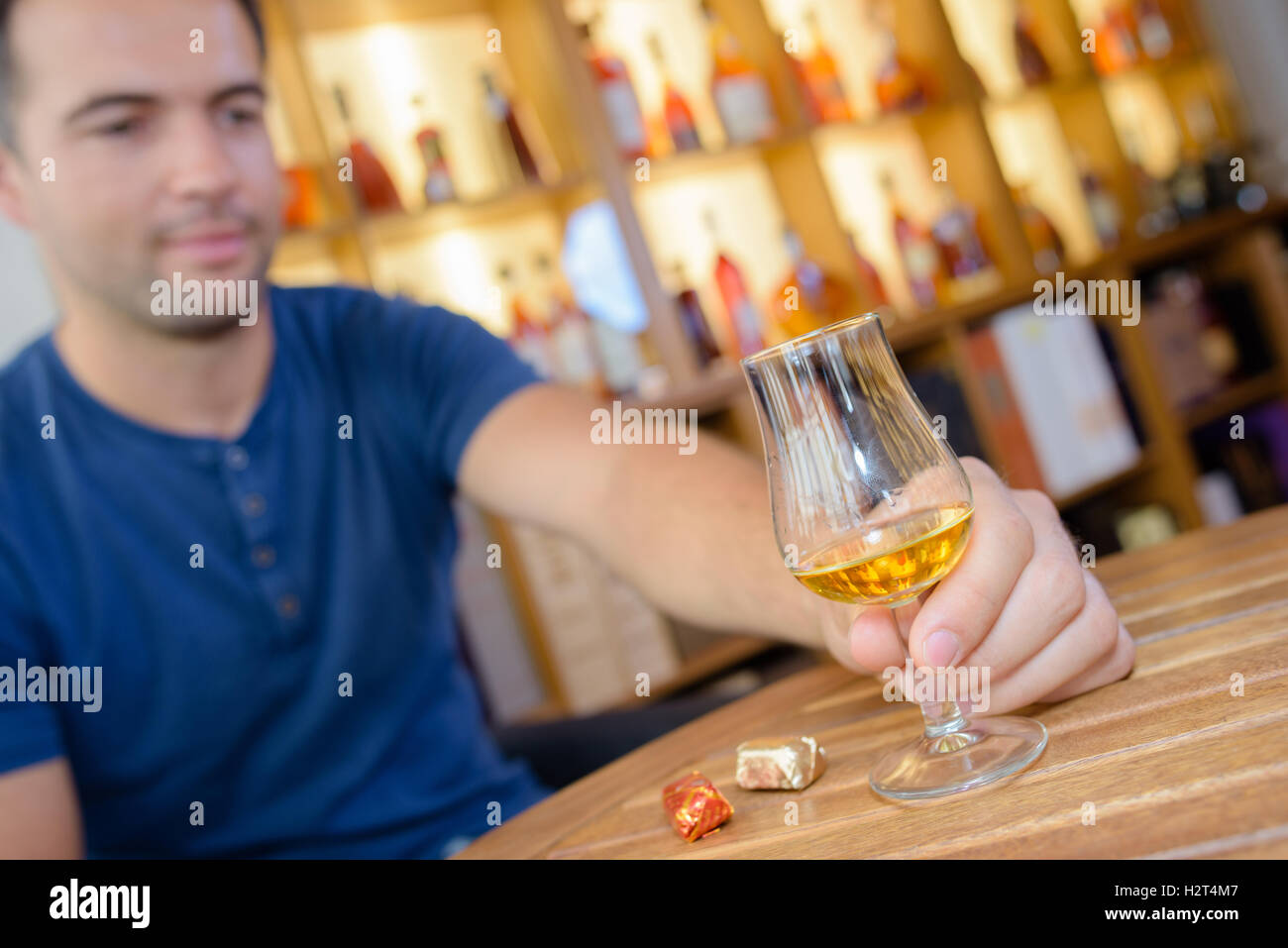 Smiling man holding glass of alcohol Stock Photo - Alamy