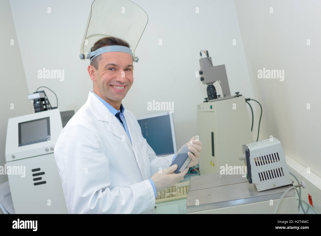 Male laboratory technician wearing visor Stock Photo - Alamy