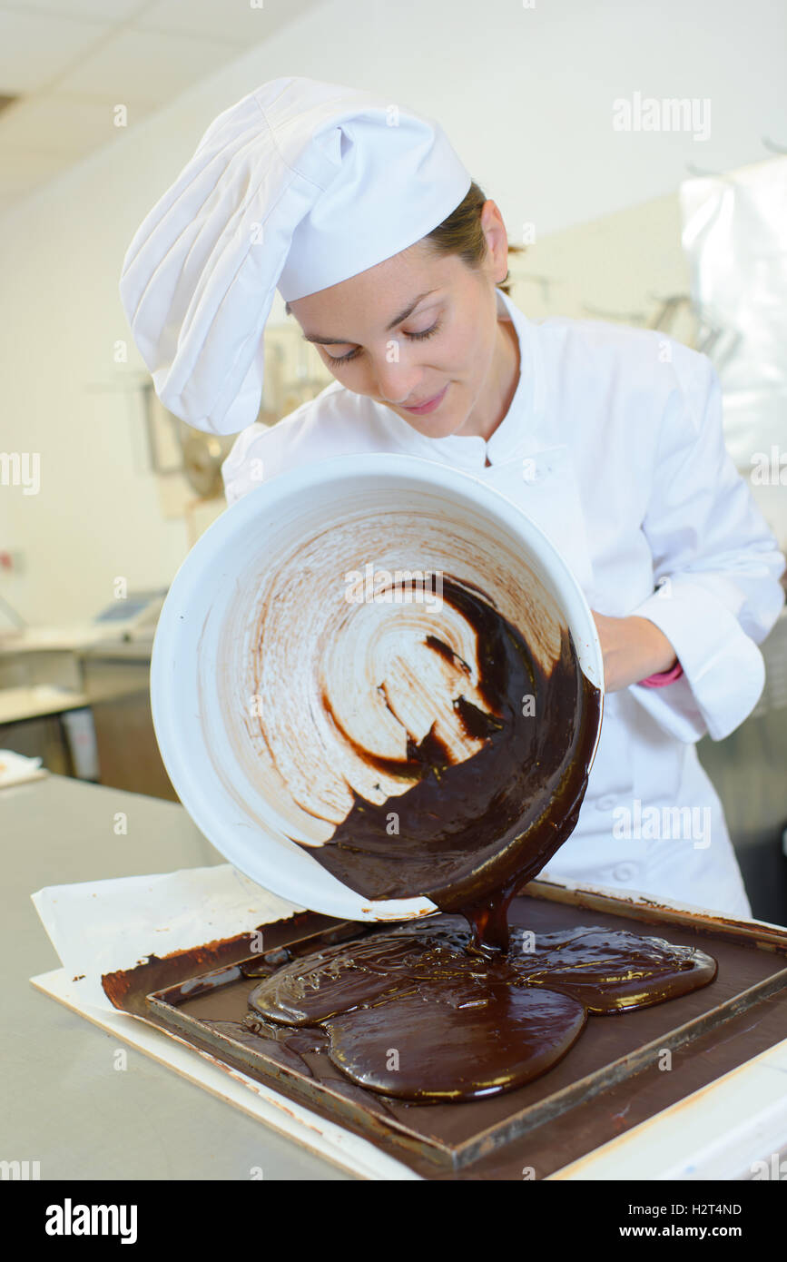 Chef pouring chocolate into baking sheet Stock Photo - Alamy