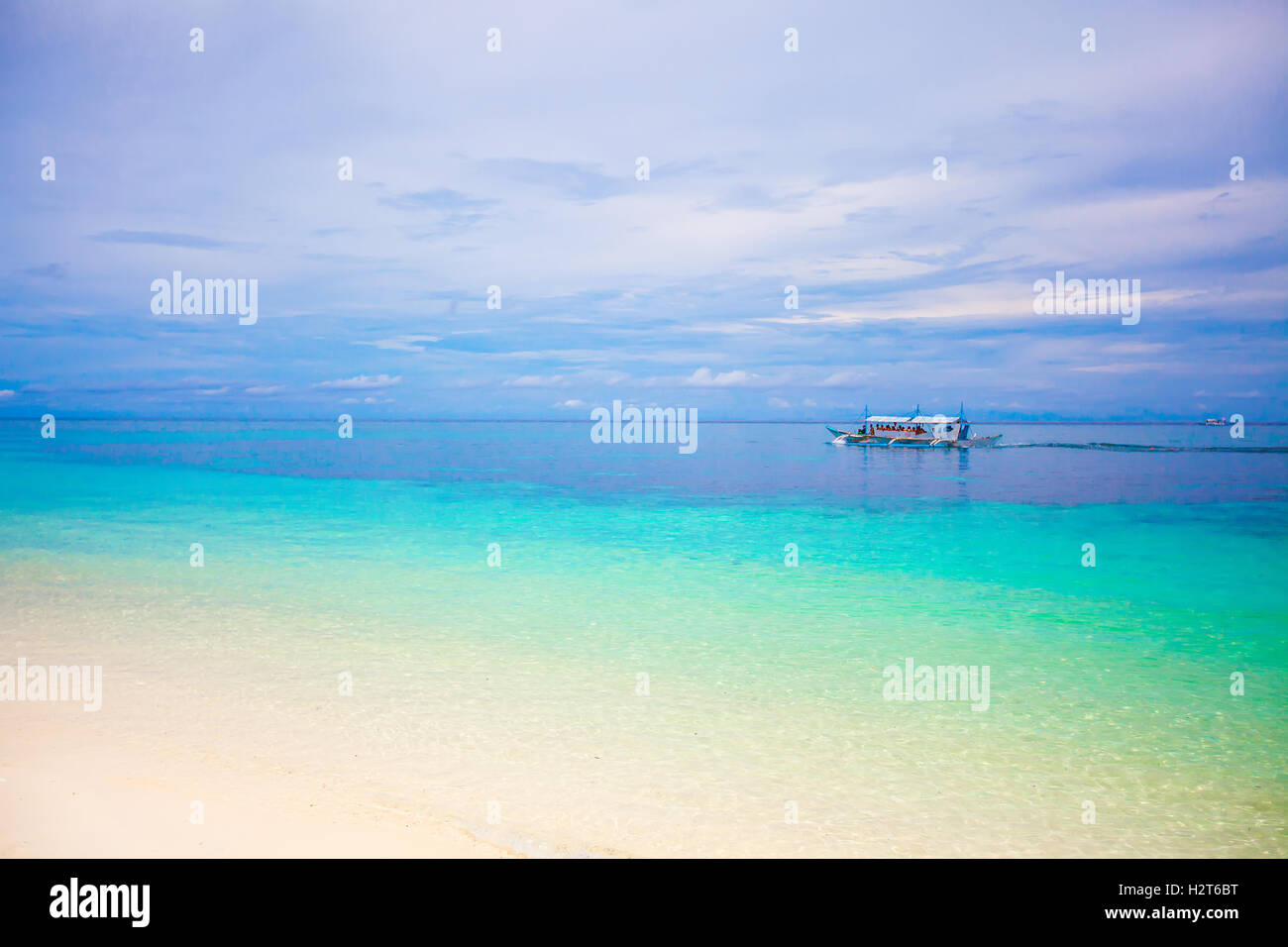 Clean turquoise water and small boat in the sea near tropical island ...